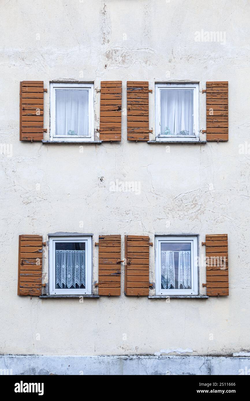 facade of house with simple older window flaps and white textured ...
