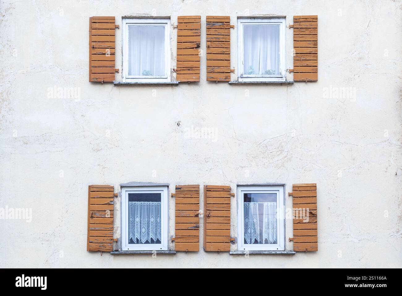 facade of house with simple older window flaps and white textured ...