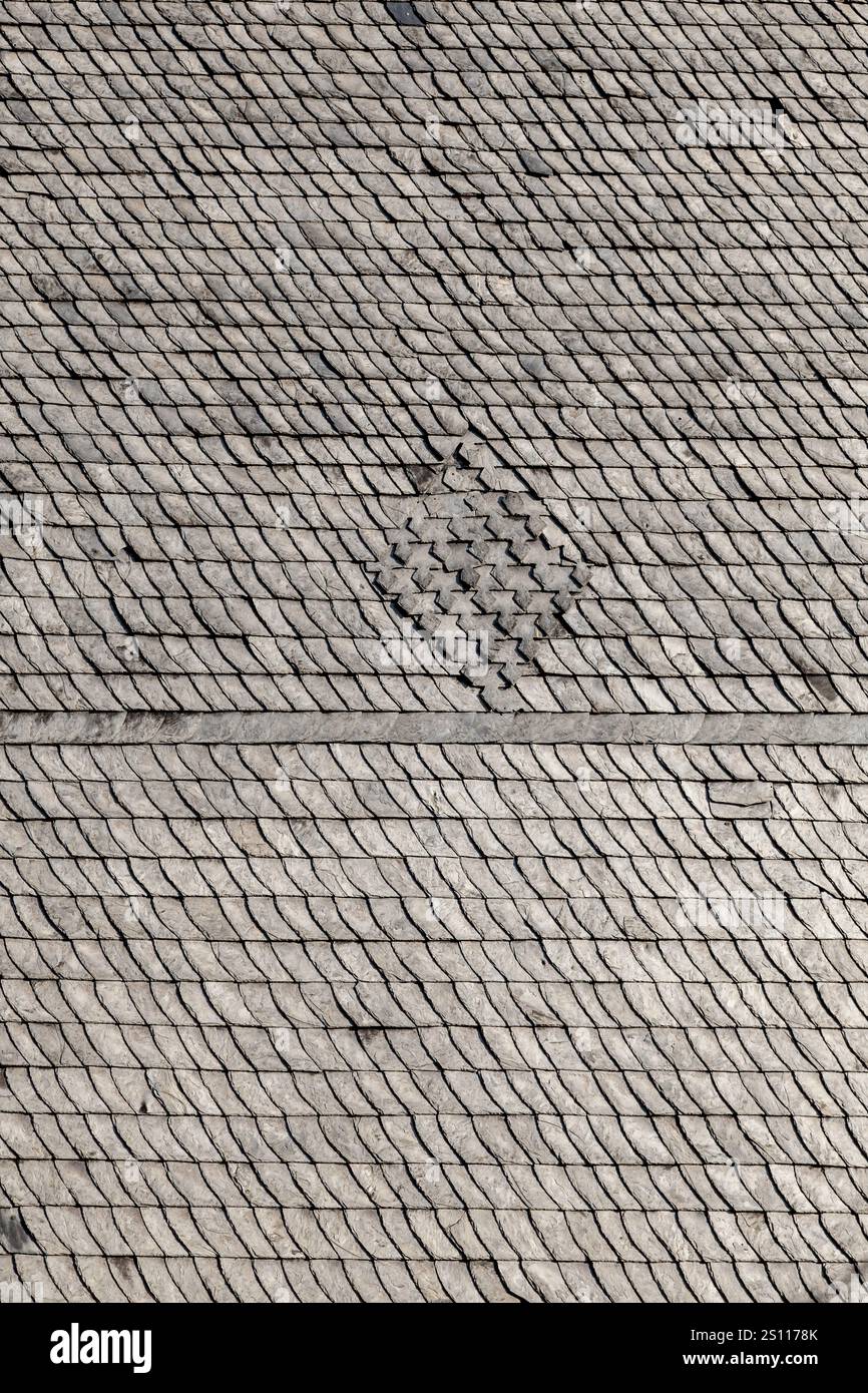 harmonic pattern of slate roof tiles at a wall of an old historic house ...