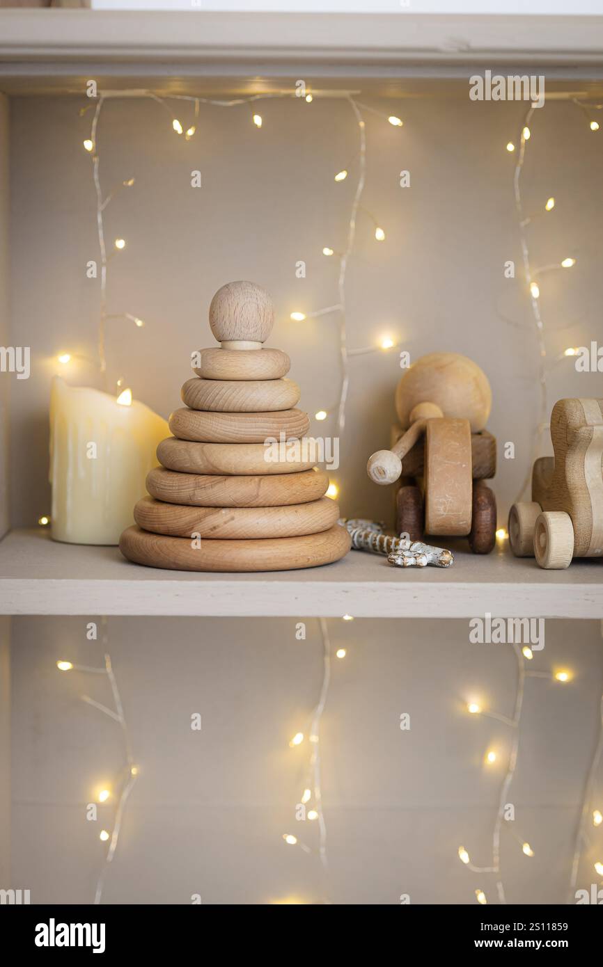 A wooden toy car is on a shelf next to a stack of wooden blocks. The ...