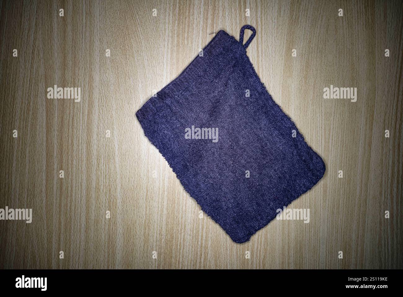 Blue washing glove isolated on brown wooden panel Stock Photo - Alamy