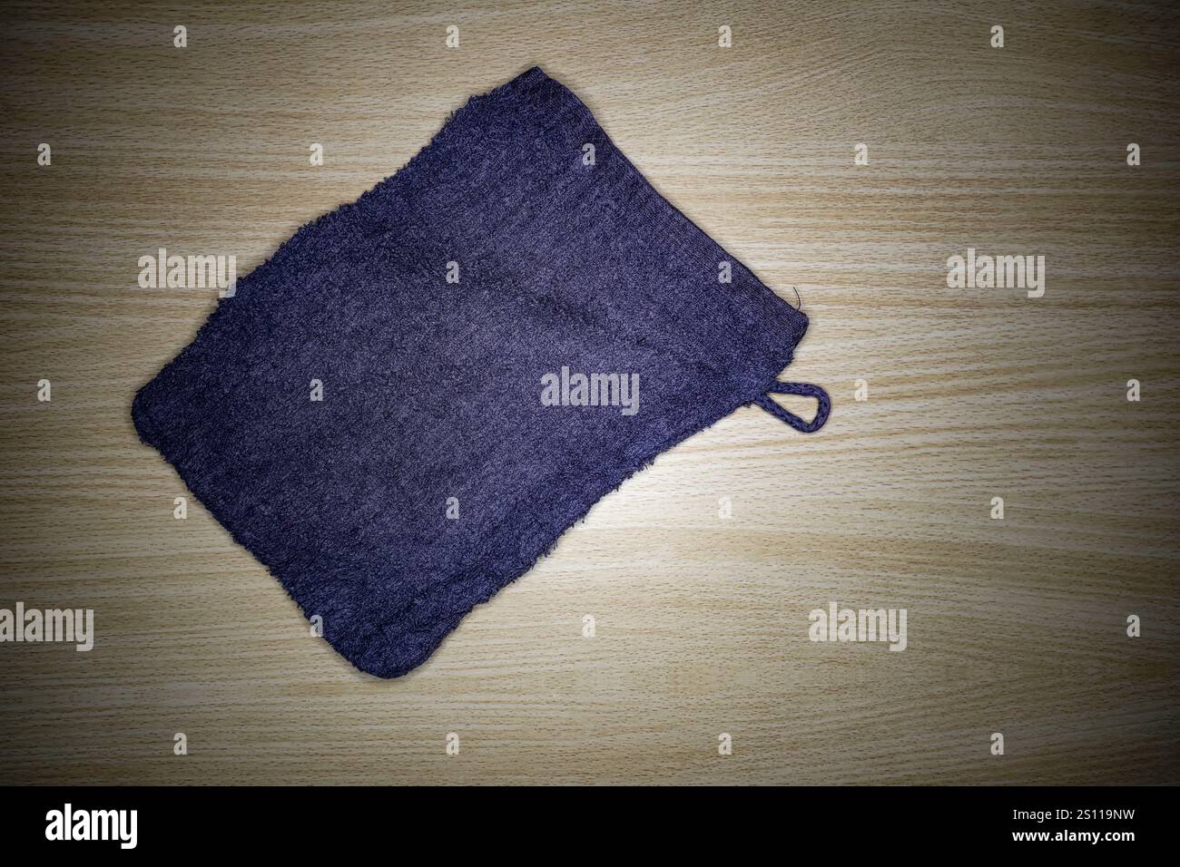 Blue washing glove isolated on brown wooden panel Stock Photo - Alamy