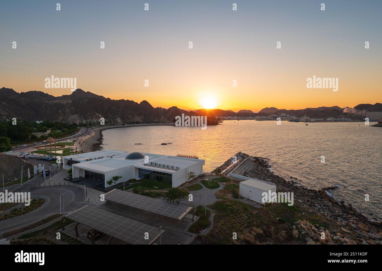 Sunset over the Muttrah Corniche in Muscat, Oman with serene waters of ...