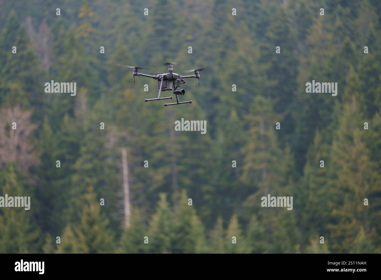 Black drone with thermal and visual cameras flying above a summer forest Stock Photo - Alamy