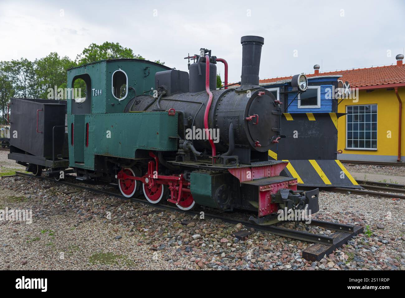 Small old locomotive in green and black on a ballast track, Polish 600 ...