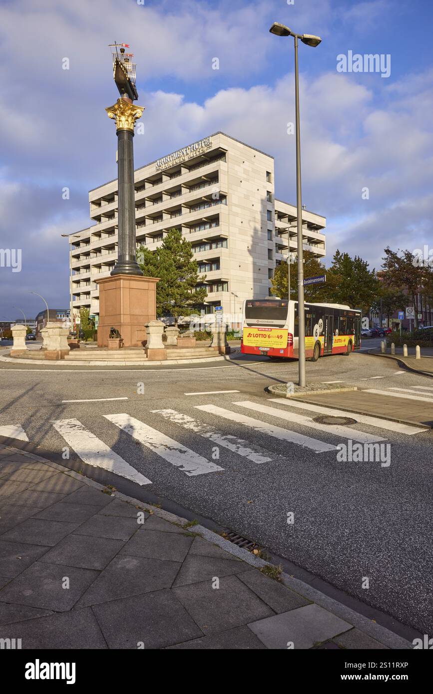 Flat hotel, granite column with metal sculpture of a cog, public bus ...