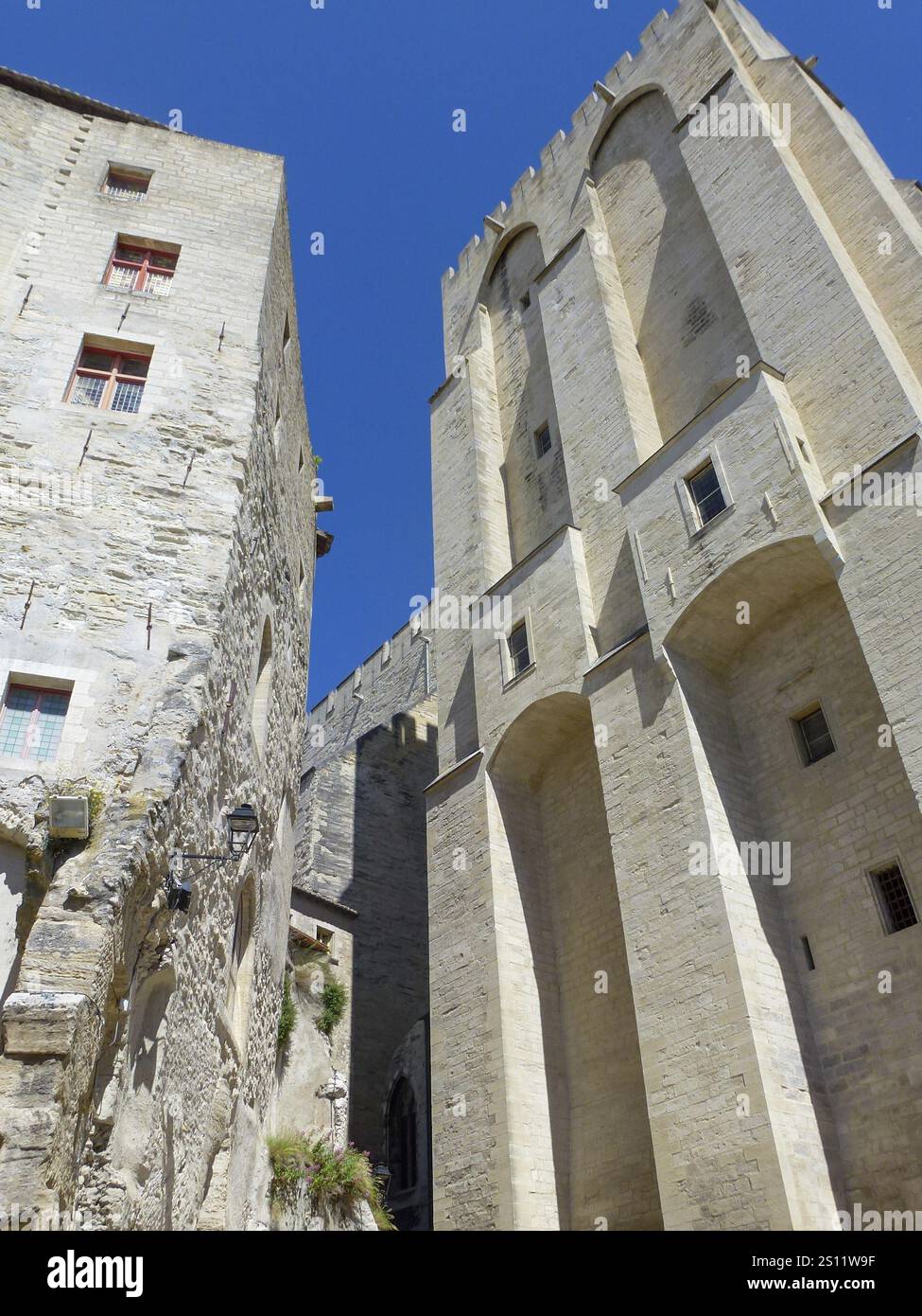 The palace of the popes in avignon, france, stands tall against a clear ...