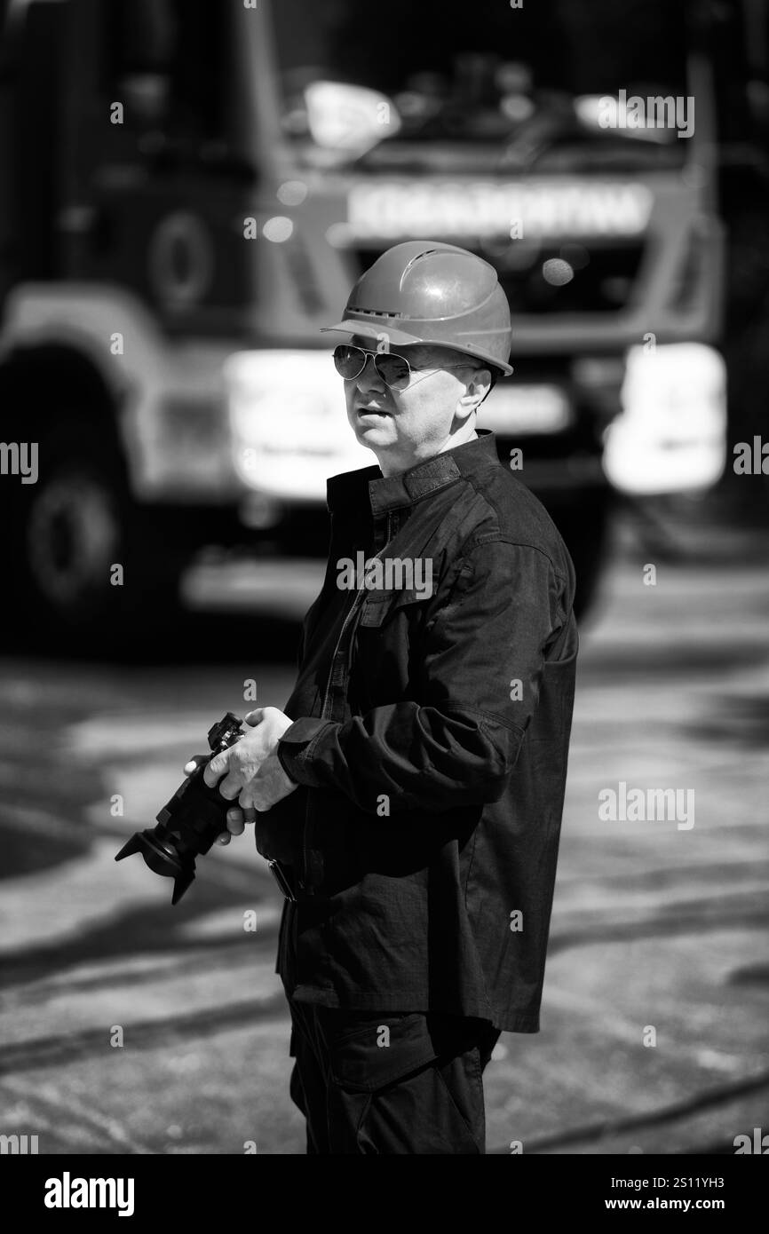 Photographer in specialized rescue uniform posing behind a fire engine ...