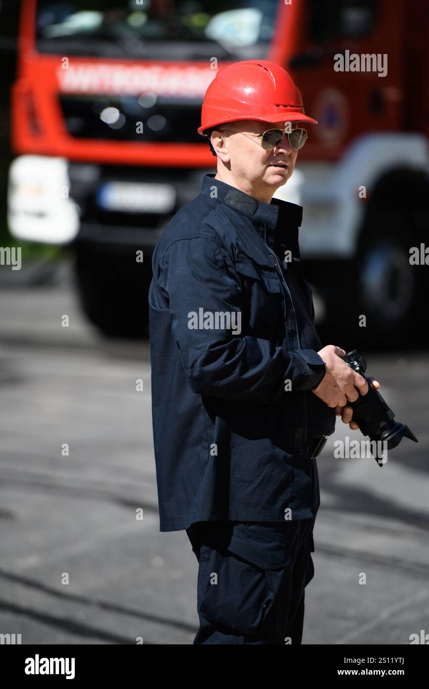 Professional photographer in blue rescue uniform and red helmet ...