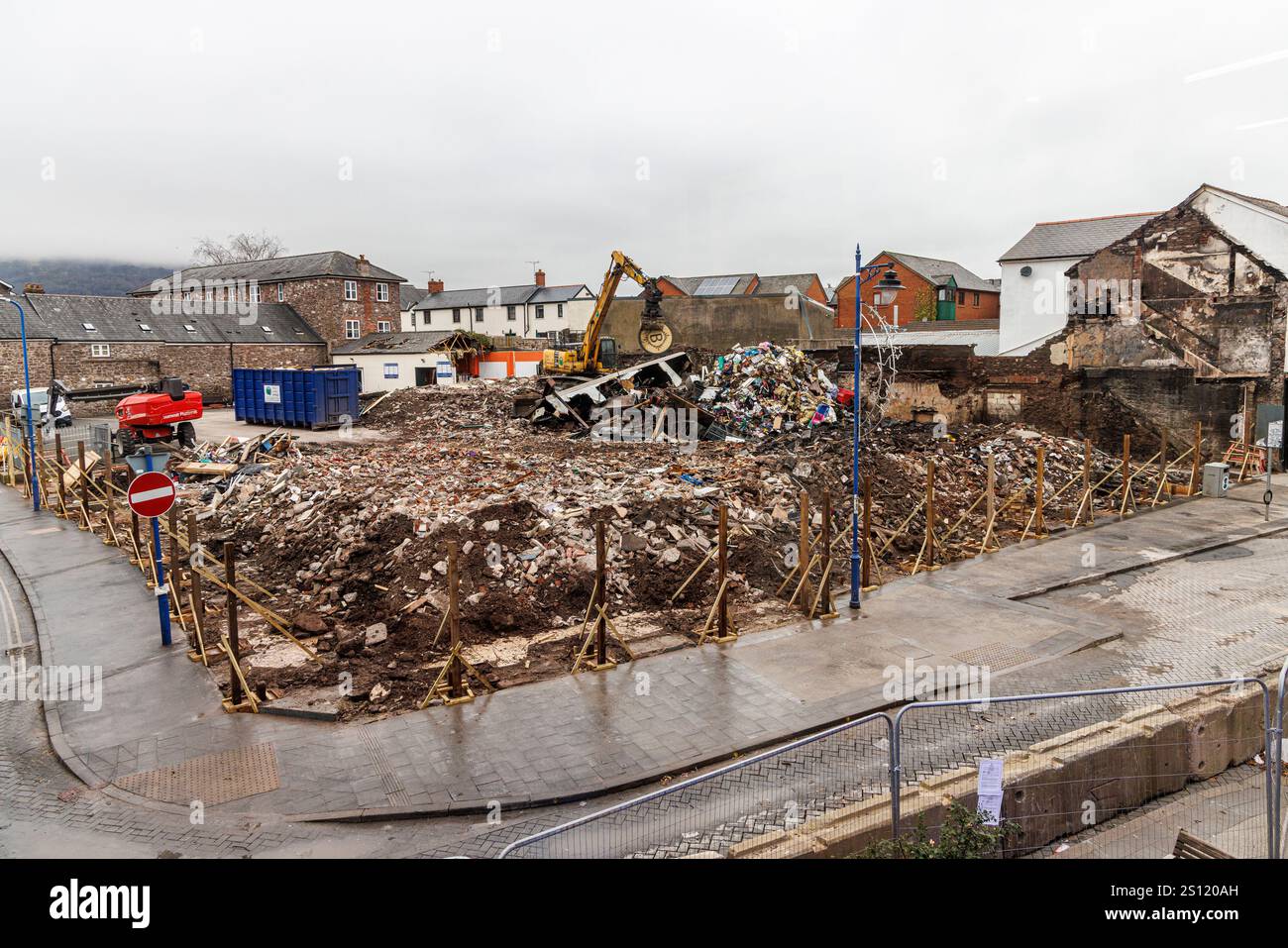 Clearance during demolition of fire damaged shops in Abergavenny, Wales ...