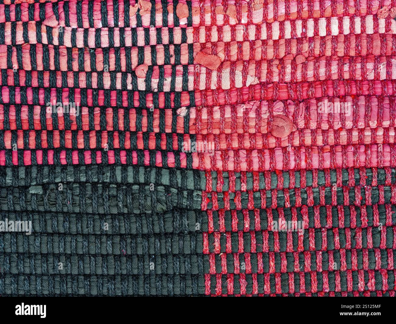 The detail of a worn woven red and black cloth rug Stock Photo - Alamy