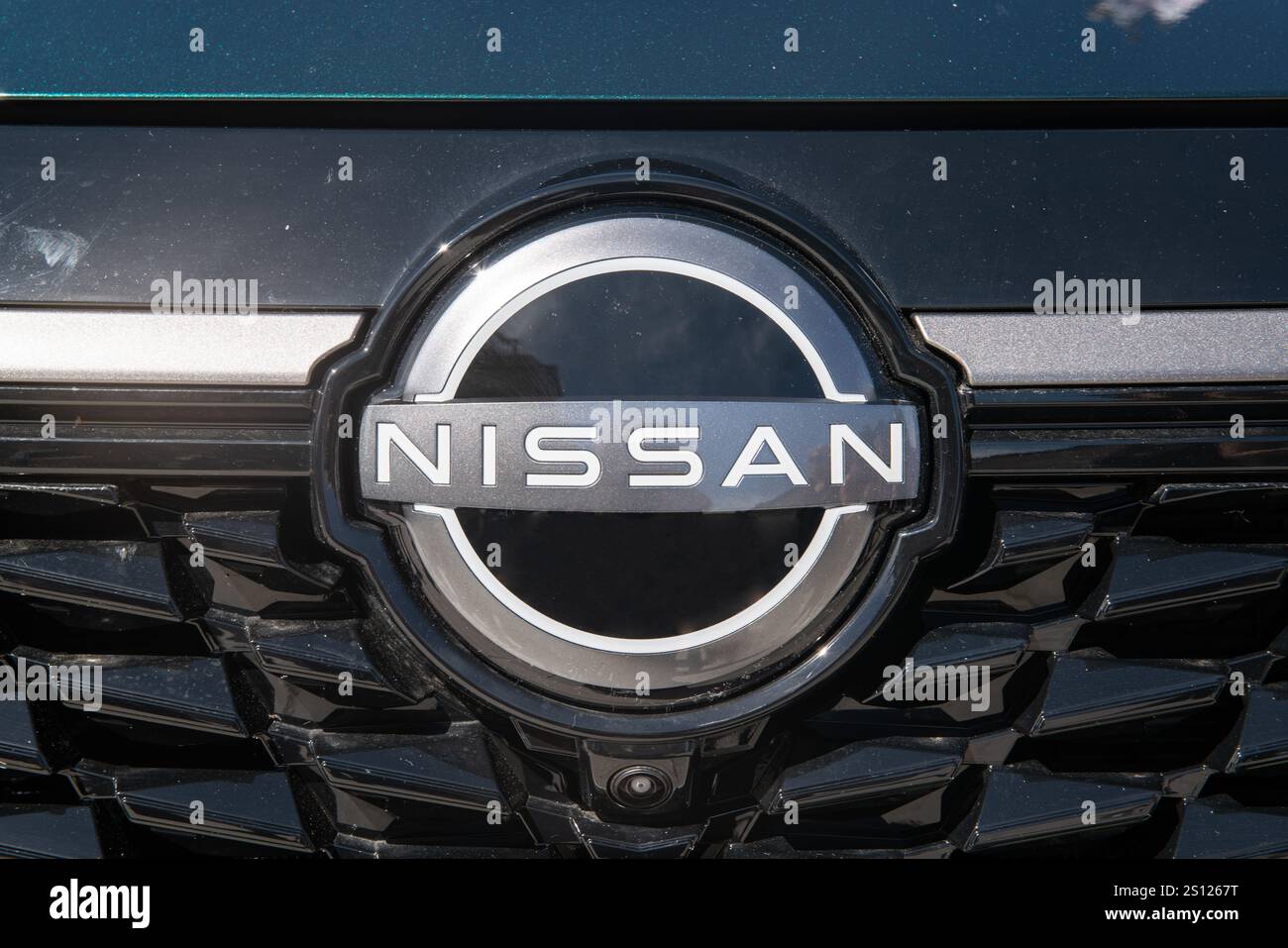 Nissan, logo with silver circle and powerful lettering, represents ...
