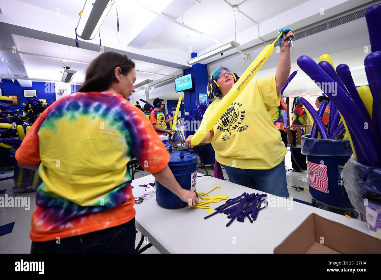 Members of the New Year's Eve balloon crew blow up yellow and purple ...