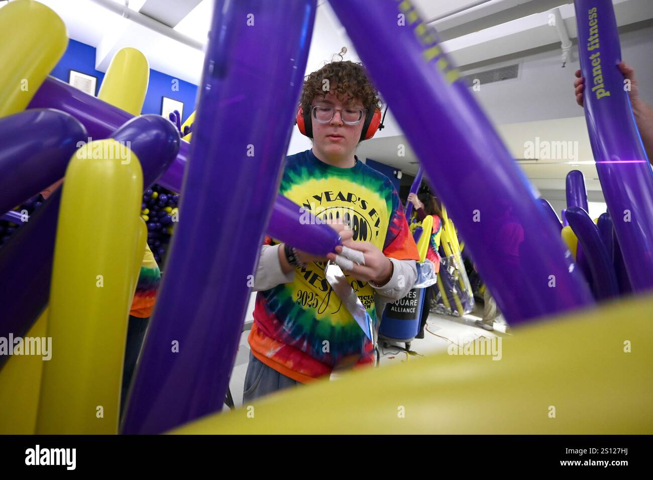 Members of the New Year's Eve balloon crew blow up yellow and purple ...