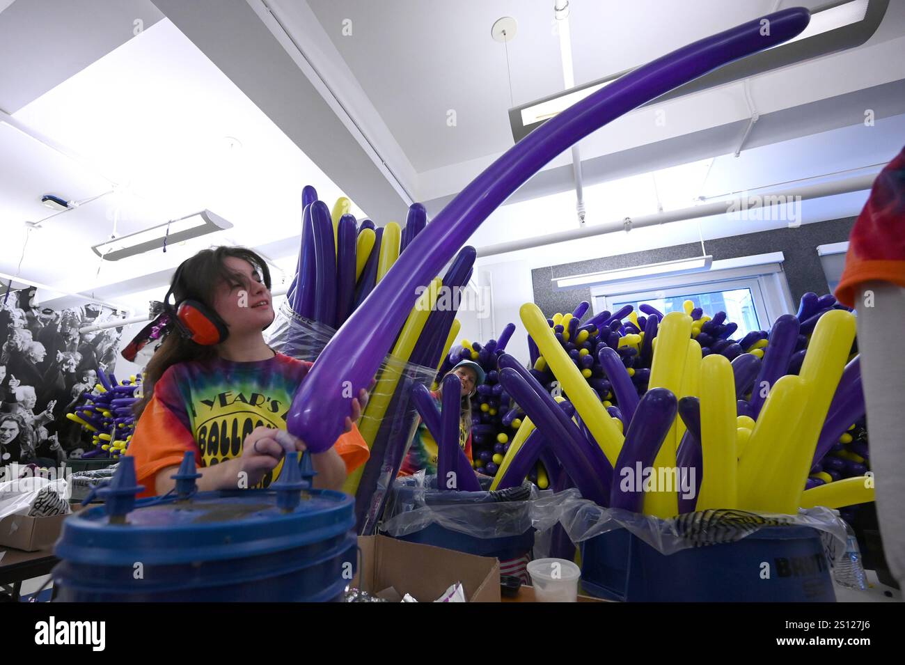 Members of the New Year's Eve balloon crew blow up yellow and purple ...