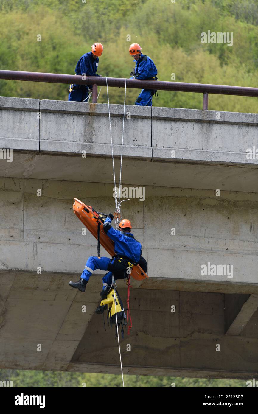 Professional rescue operation with team assisting rescuer descending ...