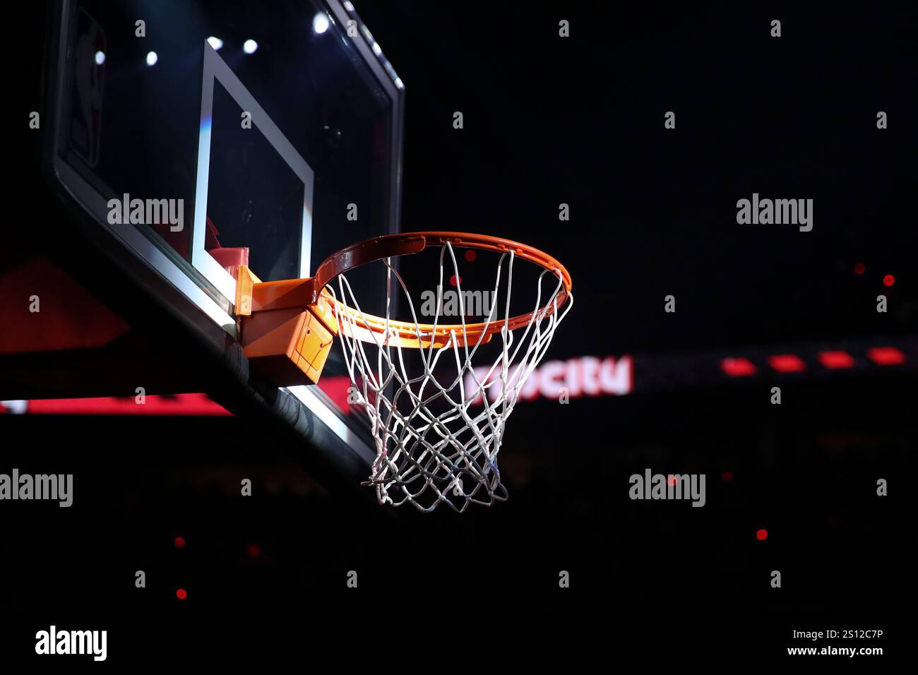 A spotlight illuminates a basketball hoop before an NBA basketball game ...