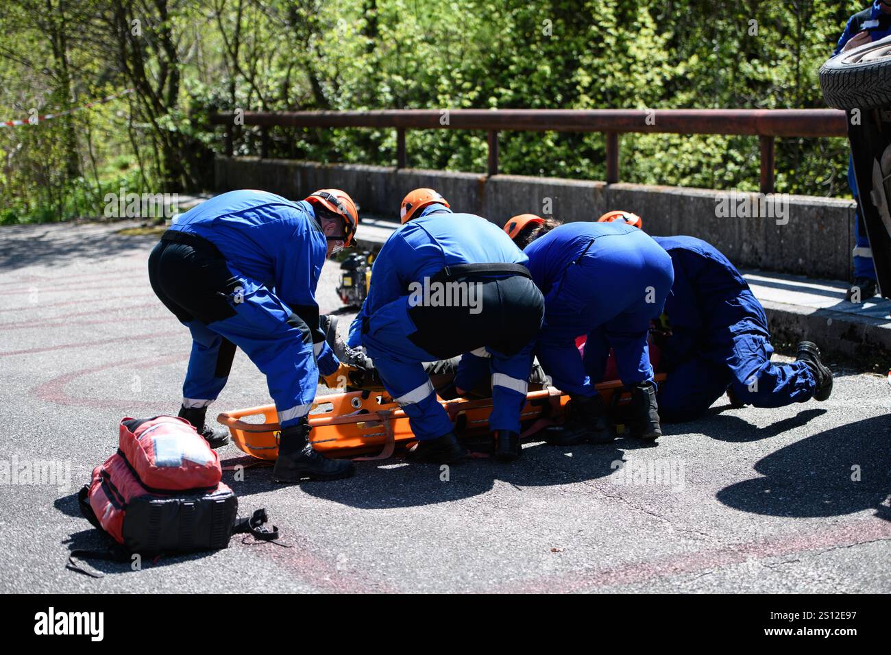 Rescuers in blue uniforms and orange helmets saving person in stretcher ...