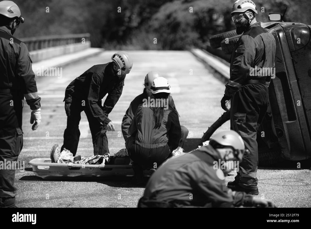 Emergency responders assisting trapped person in stretcher after car ...