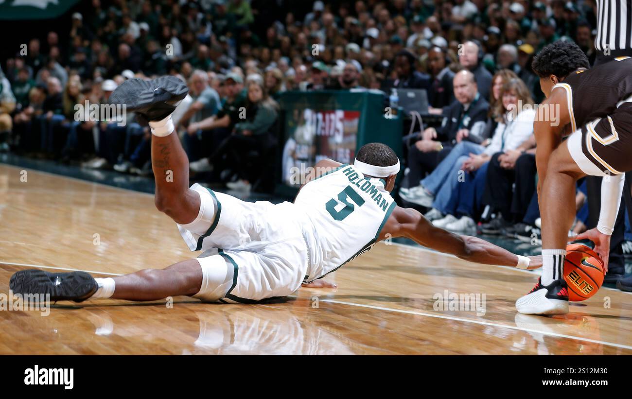 Michigan State guard Tre Holloman (5) dives for the ball against ...