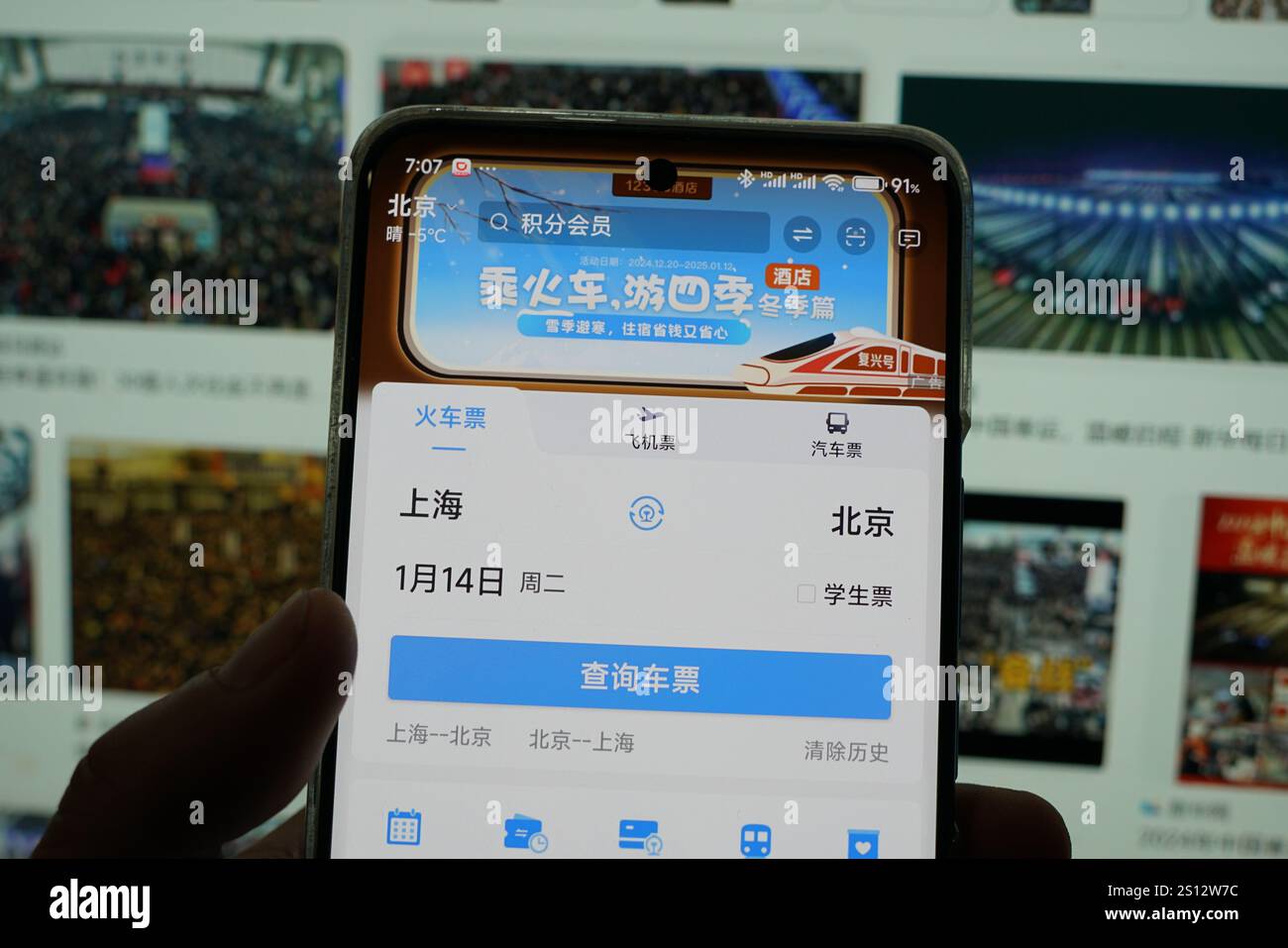 SHANGHAI, CHINA - DECEMBER 31, 2024 - A young man using the mobile phone 12306 app to check the ...