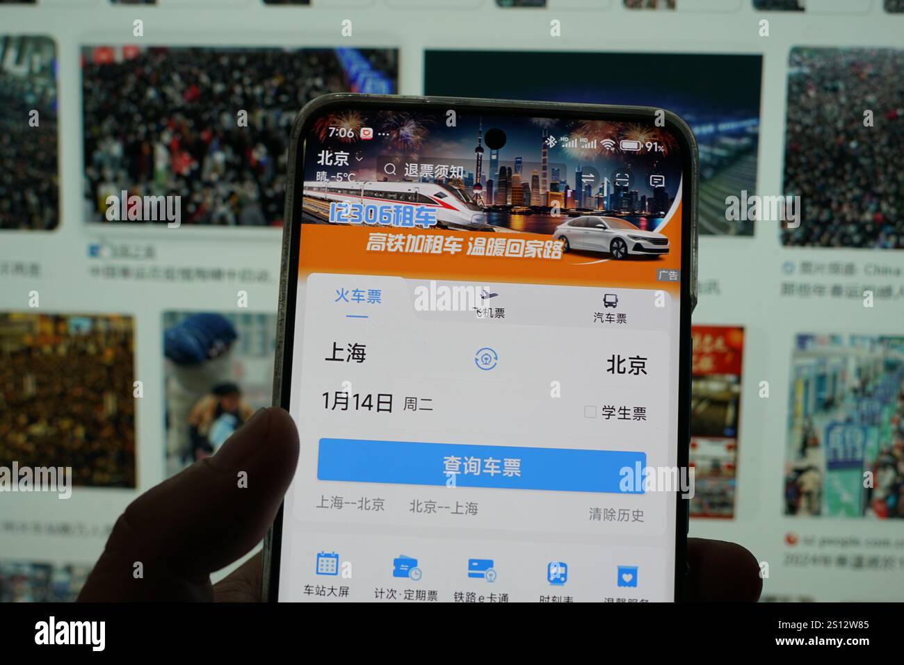 SHANGHAI, CHINA - DECEMBER 31, 2024 - A young man using the mobile phone 12306 app to check the ...