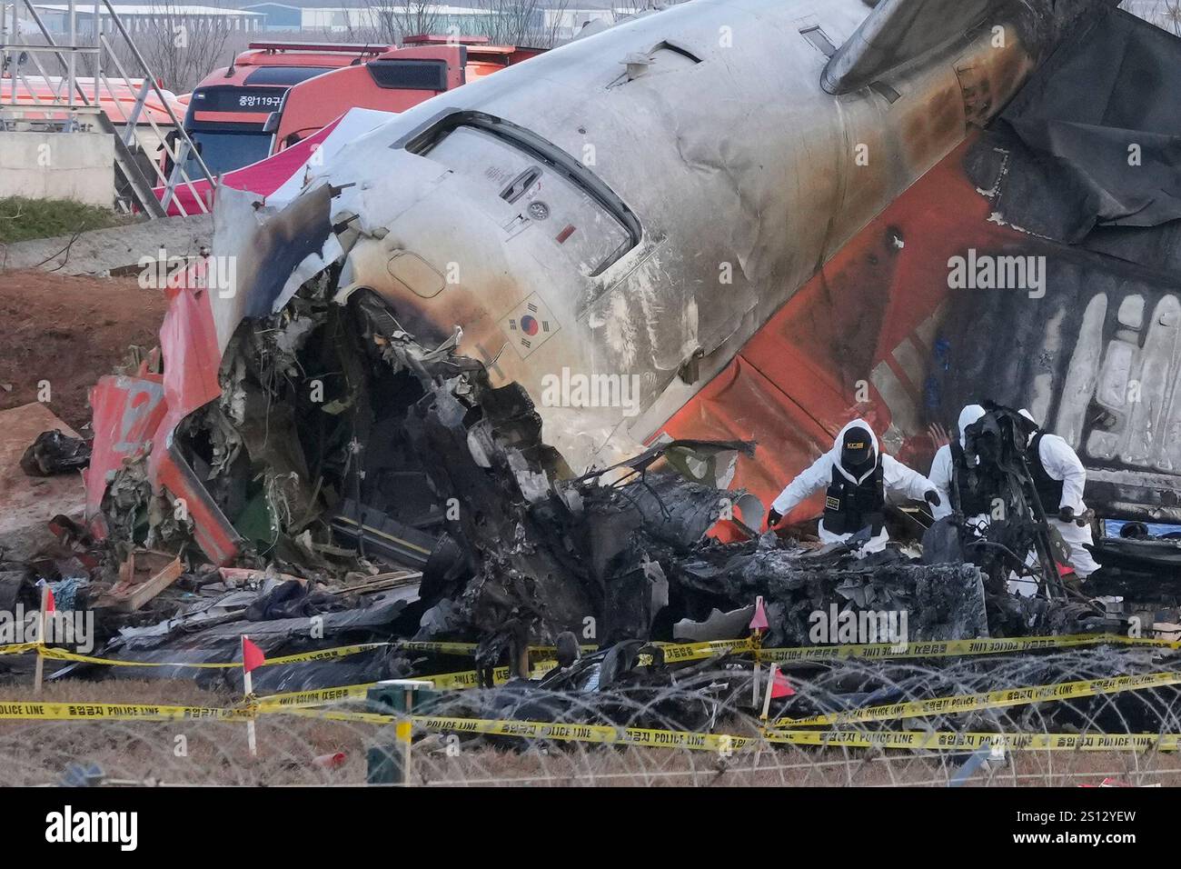 Rescue team members work at the site of a plane crash at Muan ...