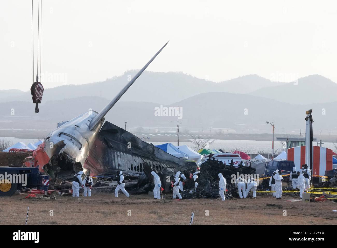Rescue team members work at the site of a plane crash at Muan ...