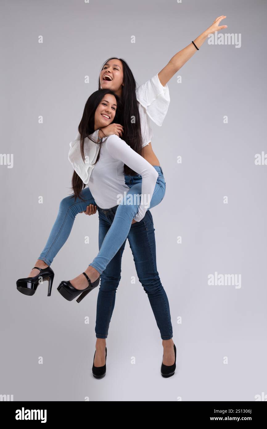 Two young women sharing laughter and joy during a playful piggyback ...