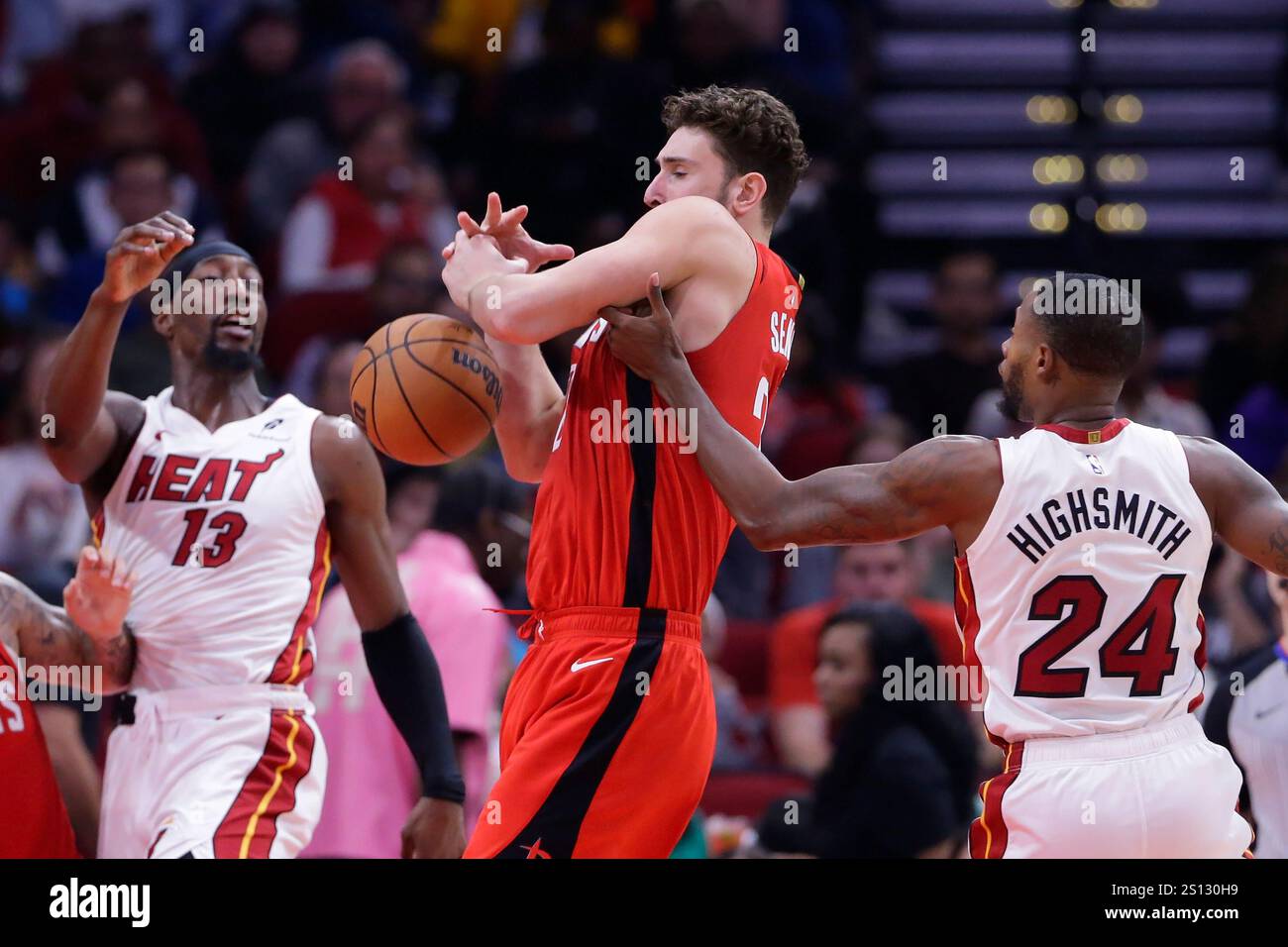 Houston Rockets center Alperen Sengun, center, loses the ball between Miami Heat center Bam ...