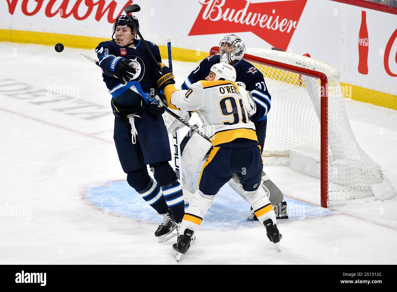 Winnipeg Jets' Logan Stanley reaches for a bouncing puck as he defends ...