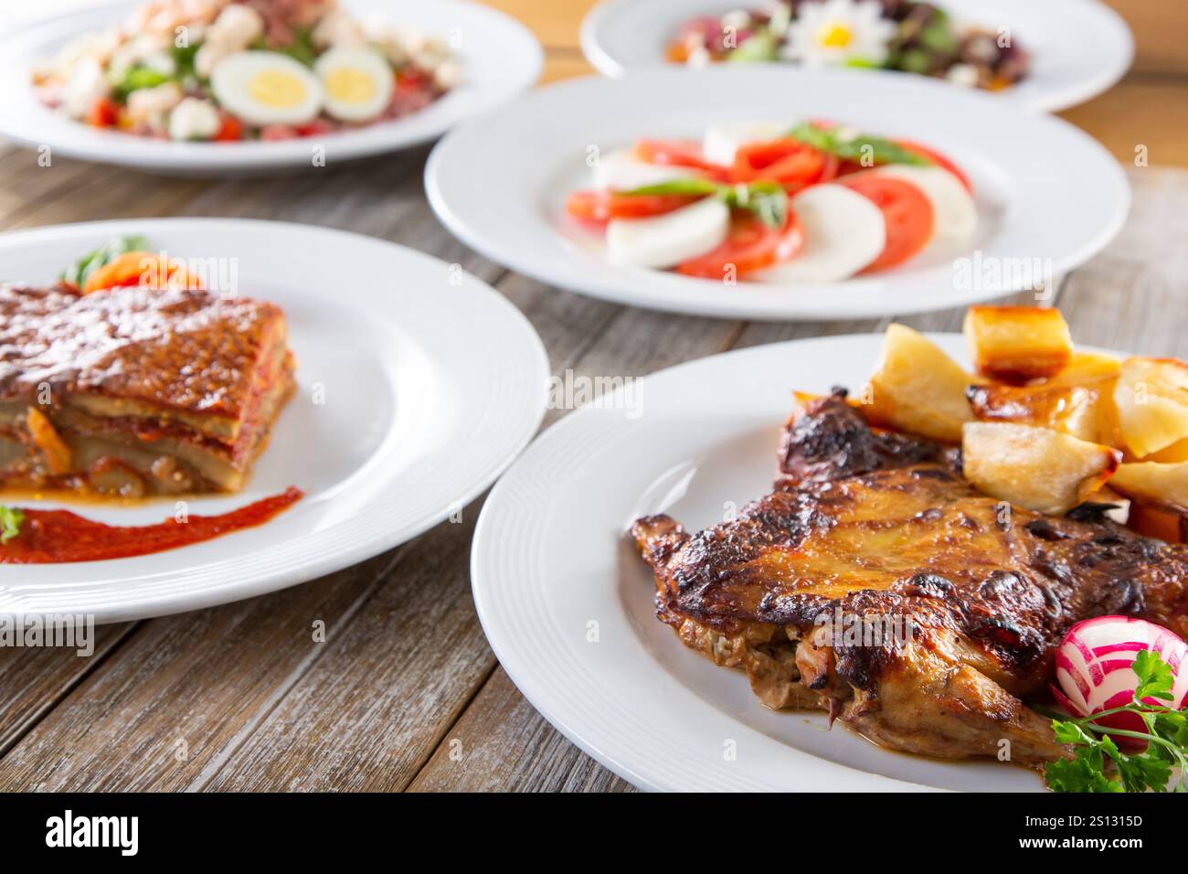 A view of several Italian plates on the table featuring roasted ...