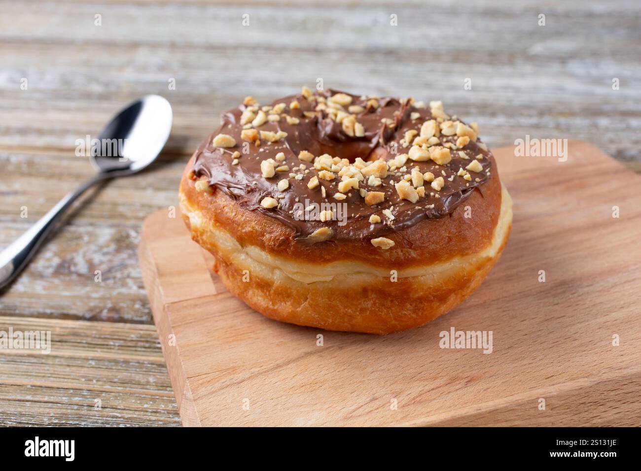 A view of a chocolate glazed donut, with peanut toppings Stock Photo ...