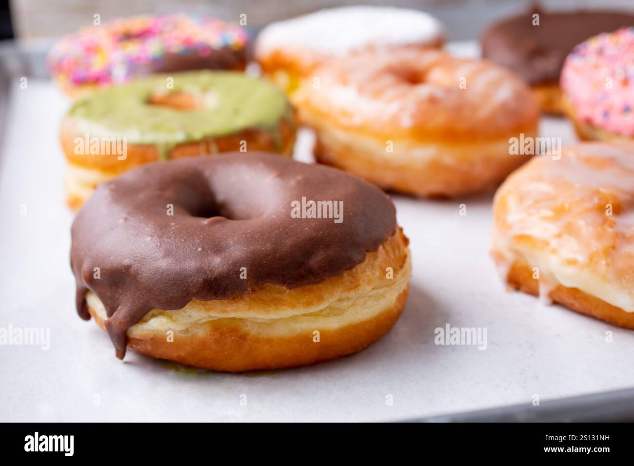 A view of an assortment of donuts on a baking sheet Stock Photo - Alamy