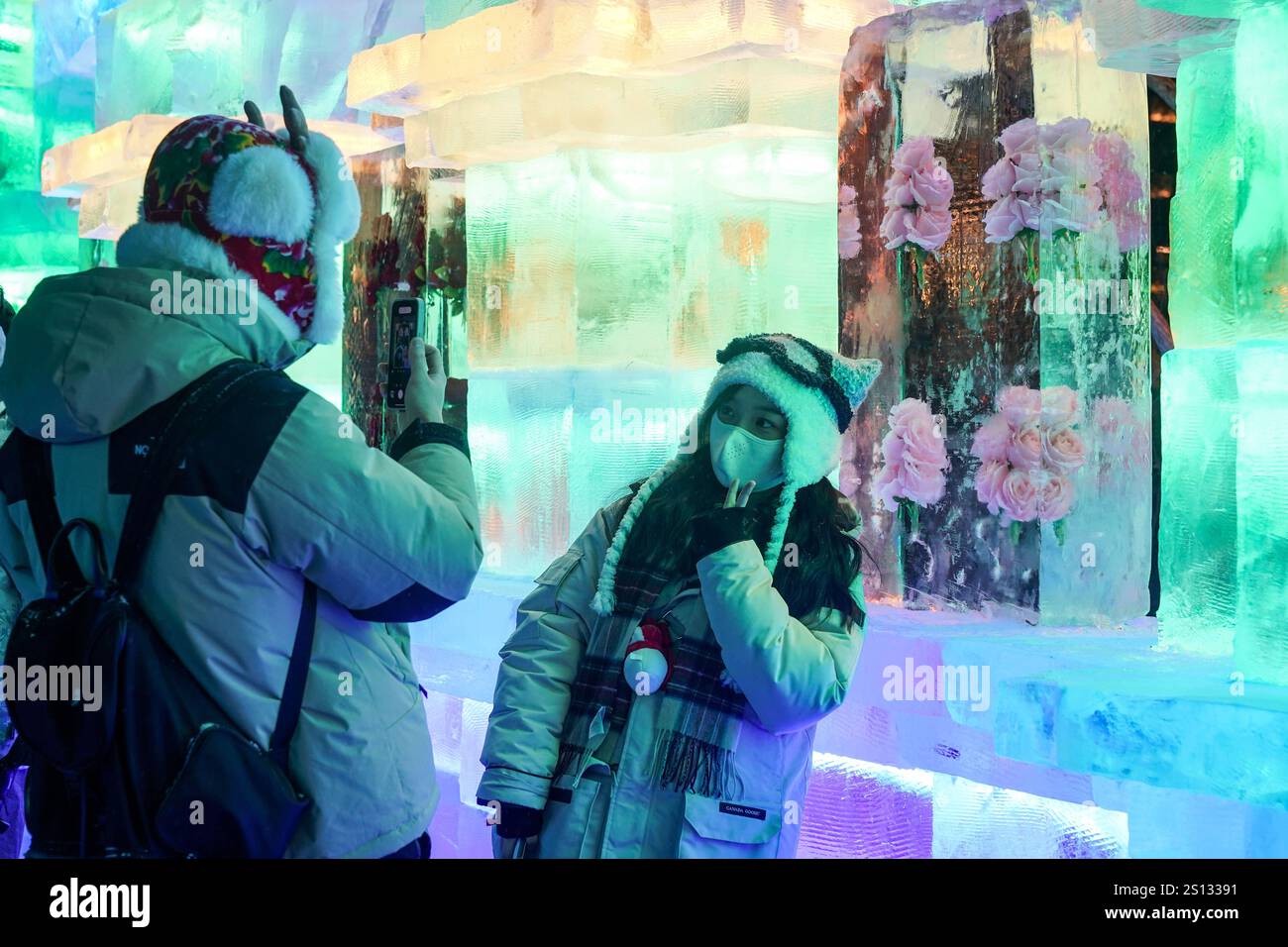 Harbin, China. 30th Dec, 2024. People visit illuminated ice lanterns ...