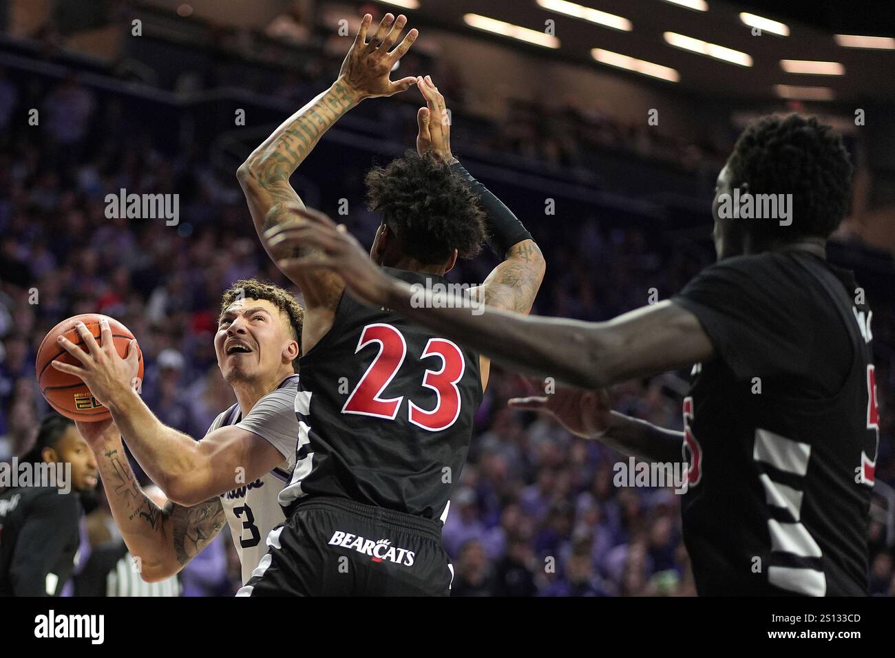 Kansas State guard Coleman Hawkins, left, looks to shoot over ...