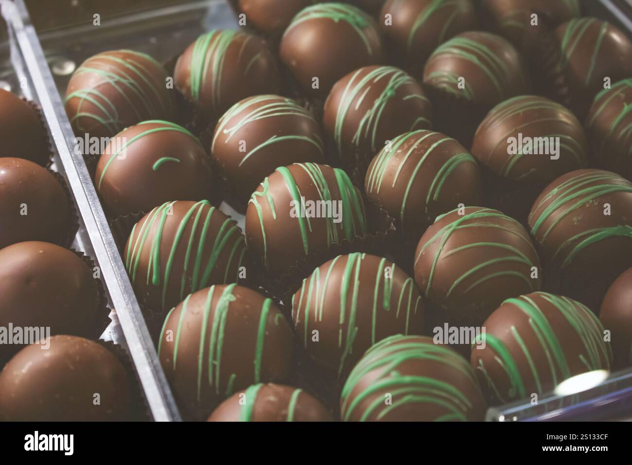 A view of several chocolate truffle balls on display at a pastry shop ...