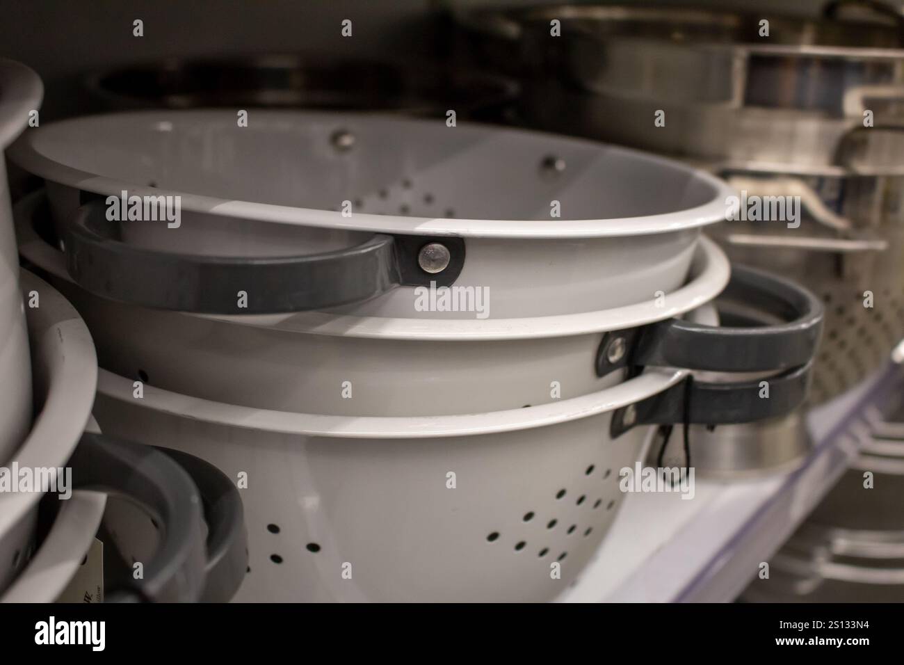 A view of a stack of white colander bowls on a shelf in the pantry ...