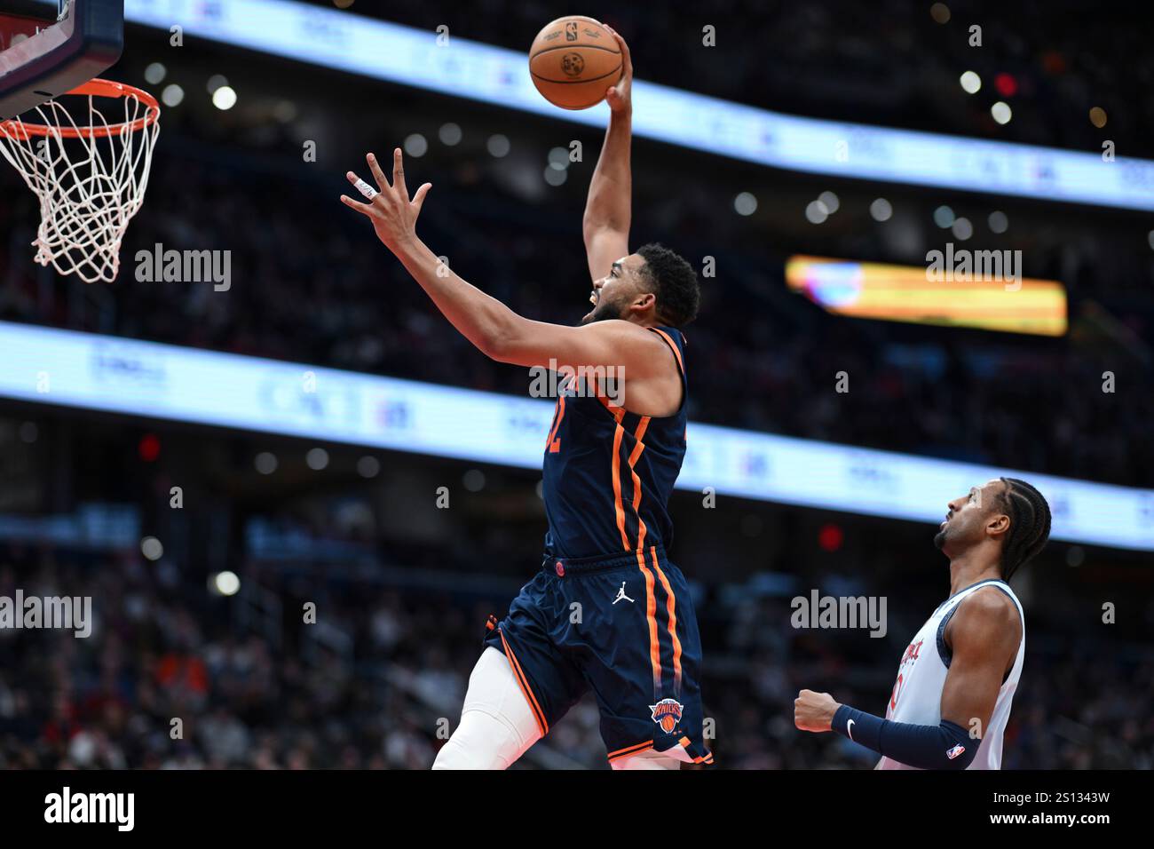New York Knicks center Karl-Anthony Towns, left, goes the basket and ...