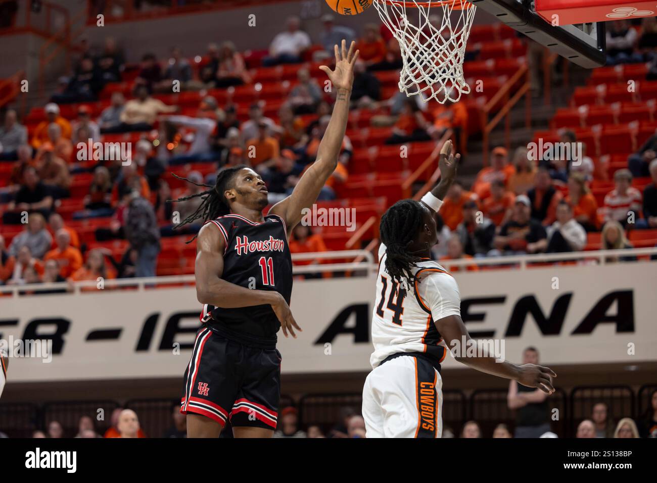 Houston forward Joseph Tugler (11) shoots the ball over Oklahoma State ...