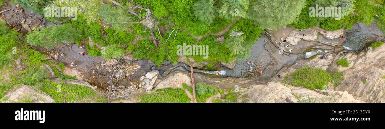 Drone view above people sliding in the Devils Bathtub waterfall and ...