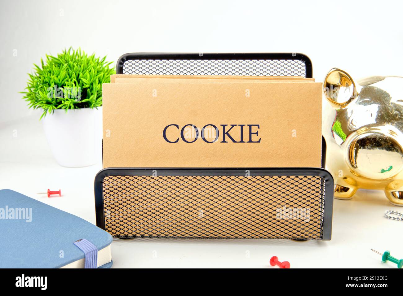A document holder displays the word 'COOKIE' in a stylish workspace adorned with a plant and a ...