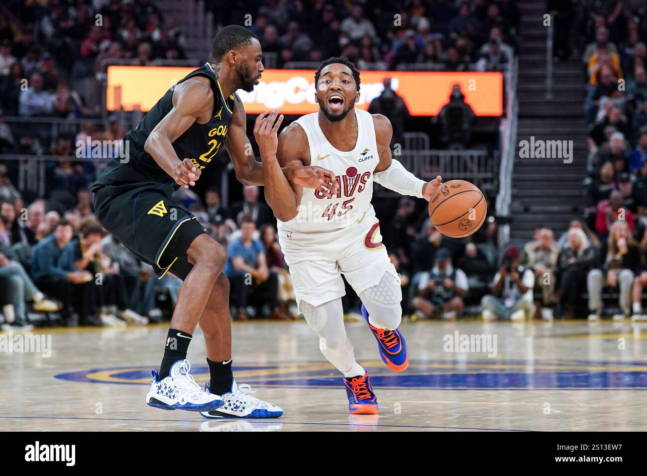 Cleveland Cavaliers guard Donovan Mitchell, right, moves the ball while ...