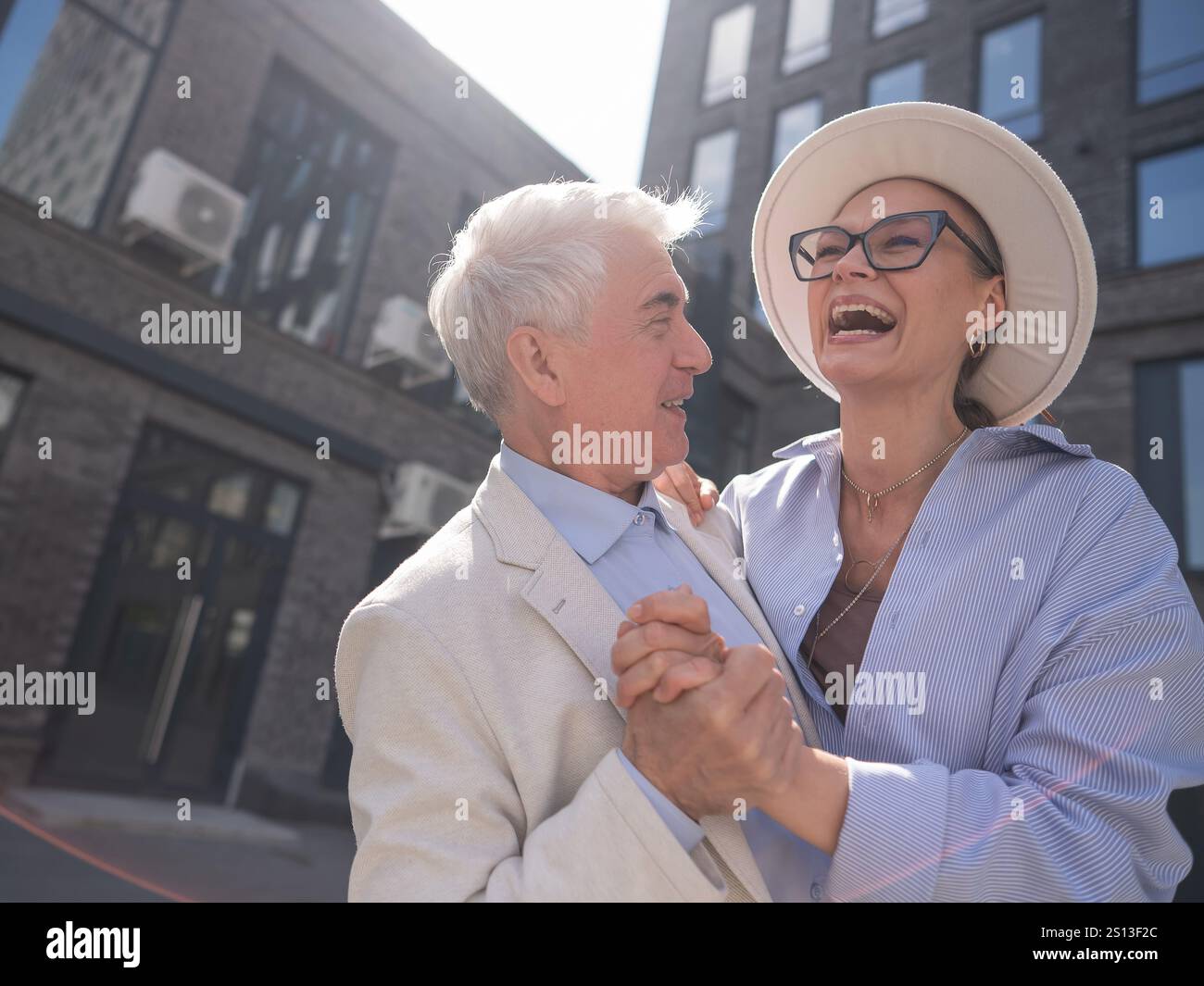 An elderly couple in love dances outdoors. A gray-haired man and a ...