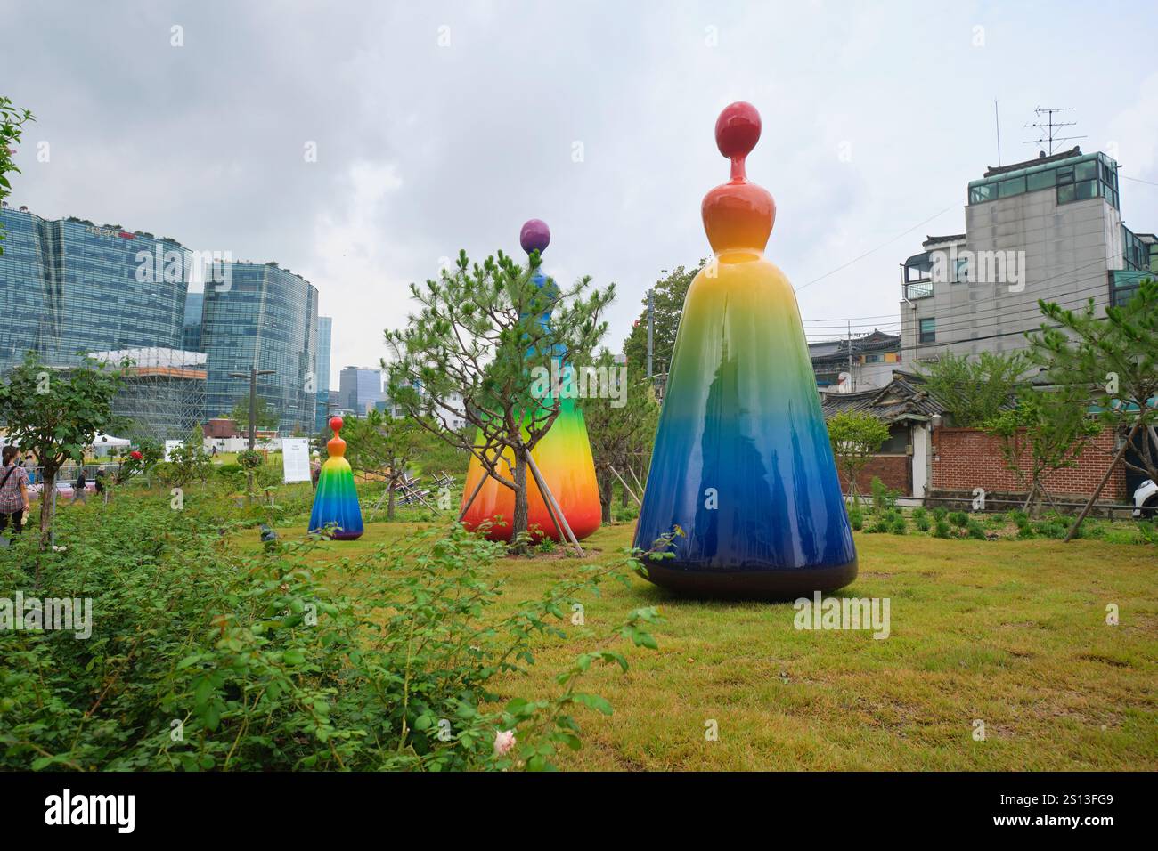 A trippy, rainbow, colorful statue in the park, lawn. At the temporary ...