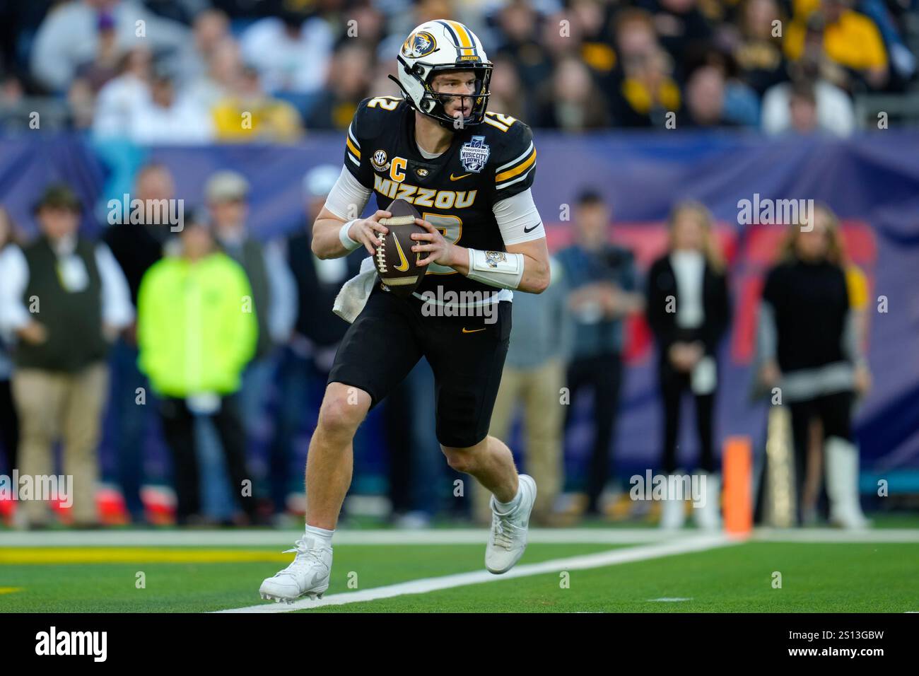Quarterback Brady Cook (Missouri Tigers, #12) rolls out looking to pass ...