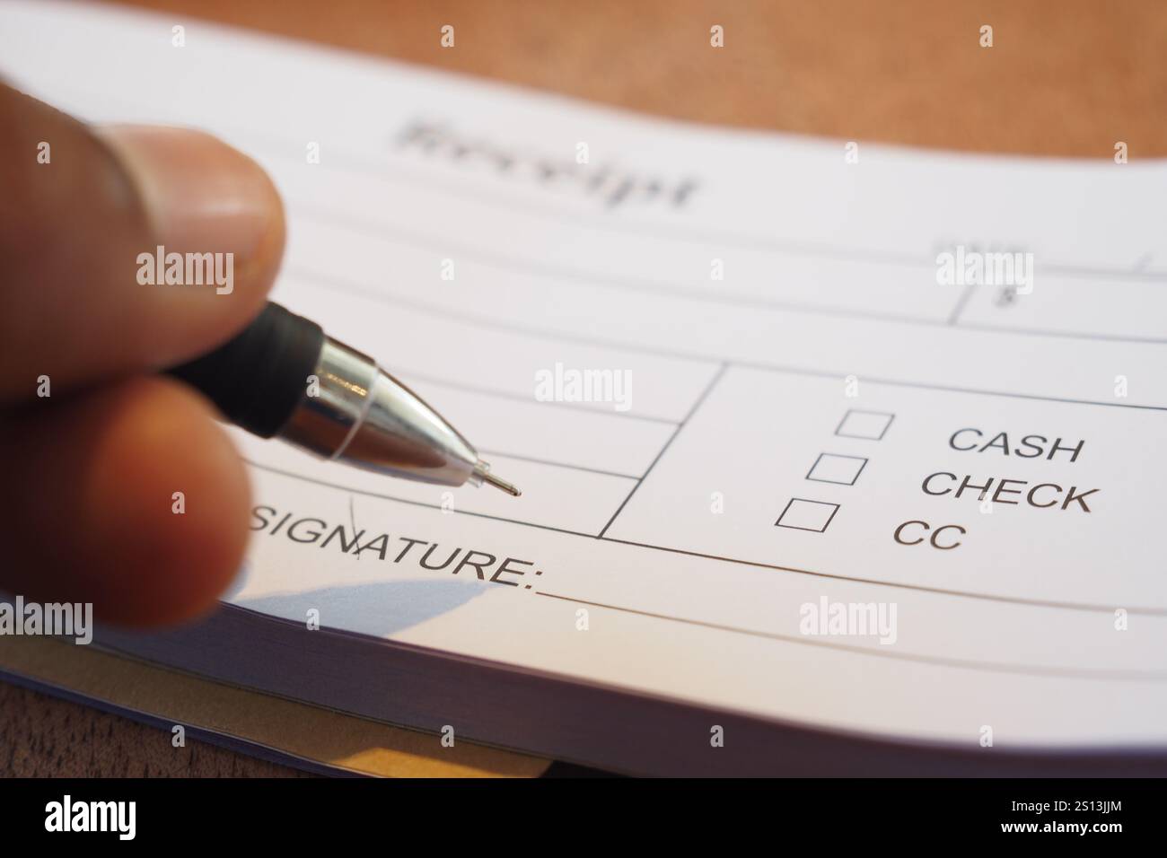 Signing the Receipt by Hand Using a Pen on the Payment Form Provided ...