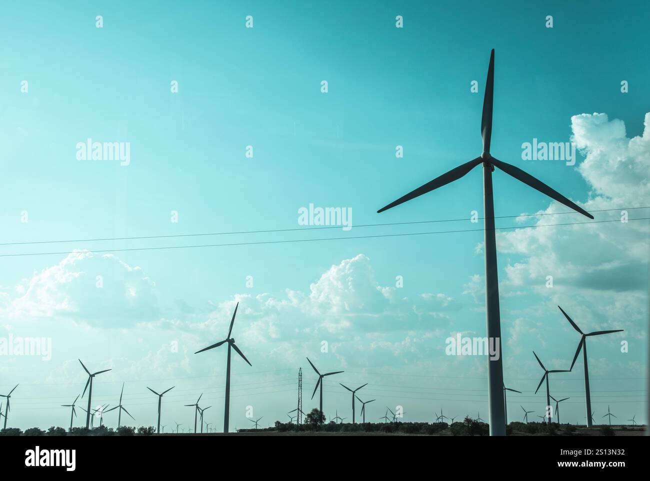 Wind turbines with propellers Energy generator on wind farm against blue sky. Natural renewable ...