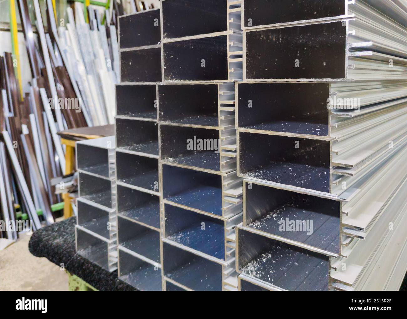 Pieces of rack profile for facade glazing lie on the assembly table ...