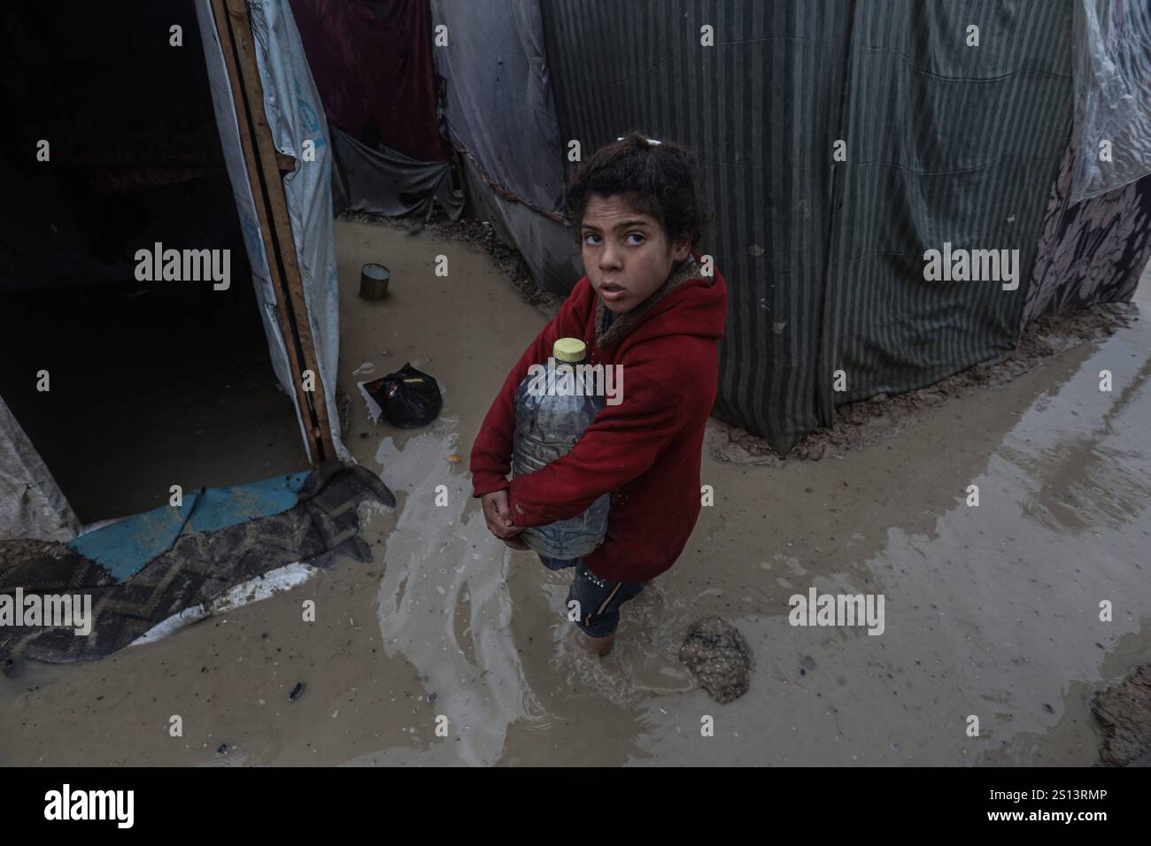 Palestinians, including children, line up to collect drinking water ...